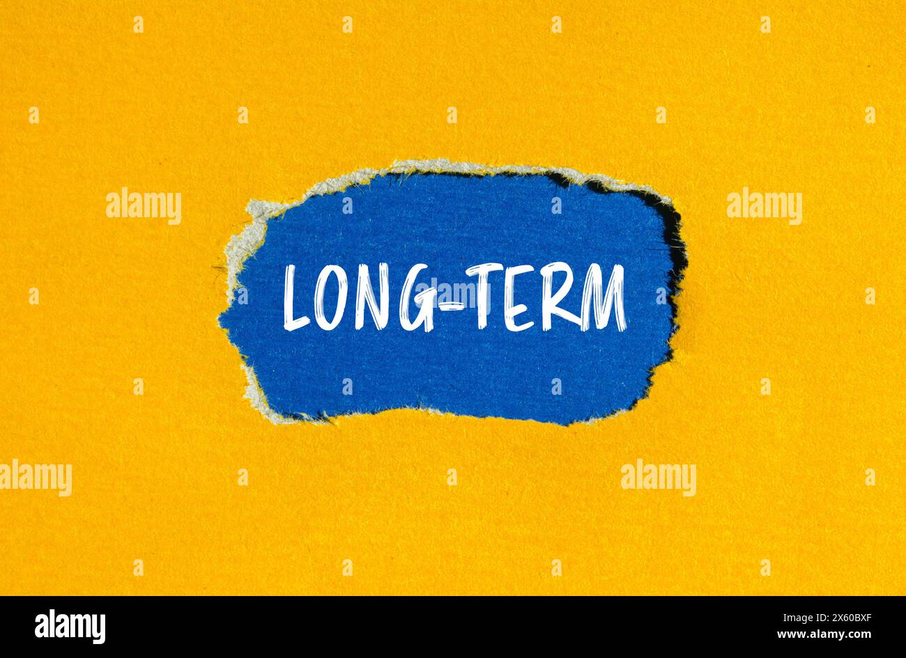 Long term words written on ripped yellow paper with blue background. Conceptual long term symbol ...
