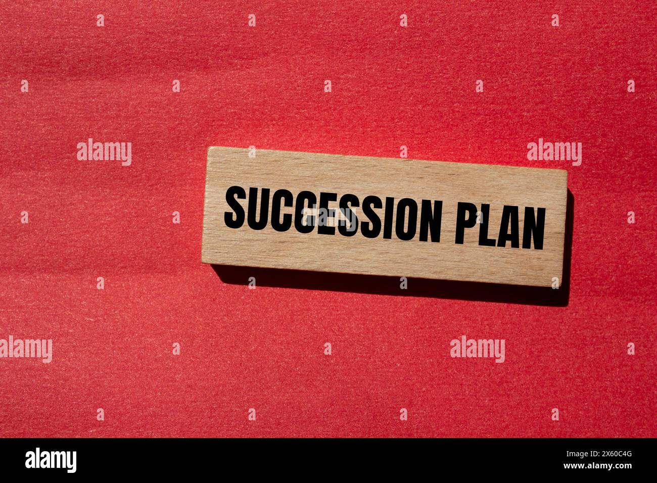 Succession plan words written on wooden block with red background ...