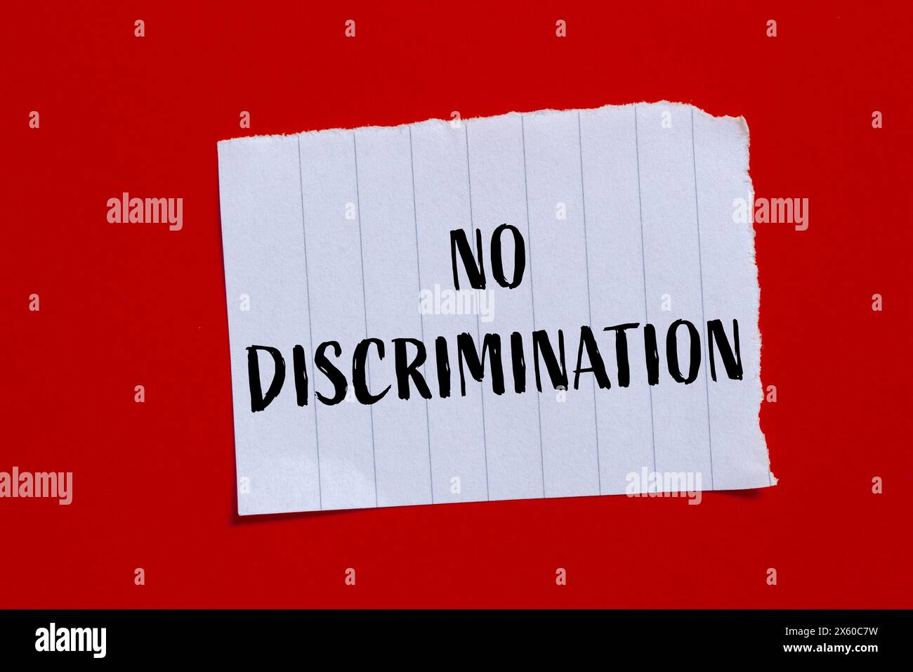 No discrimination words written on ripped paper with red background ...