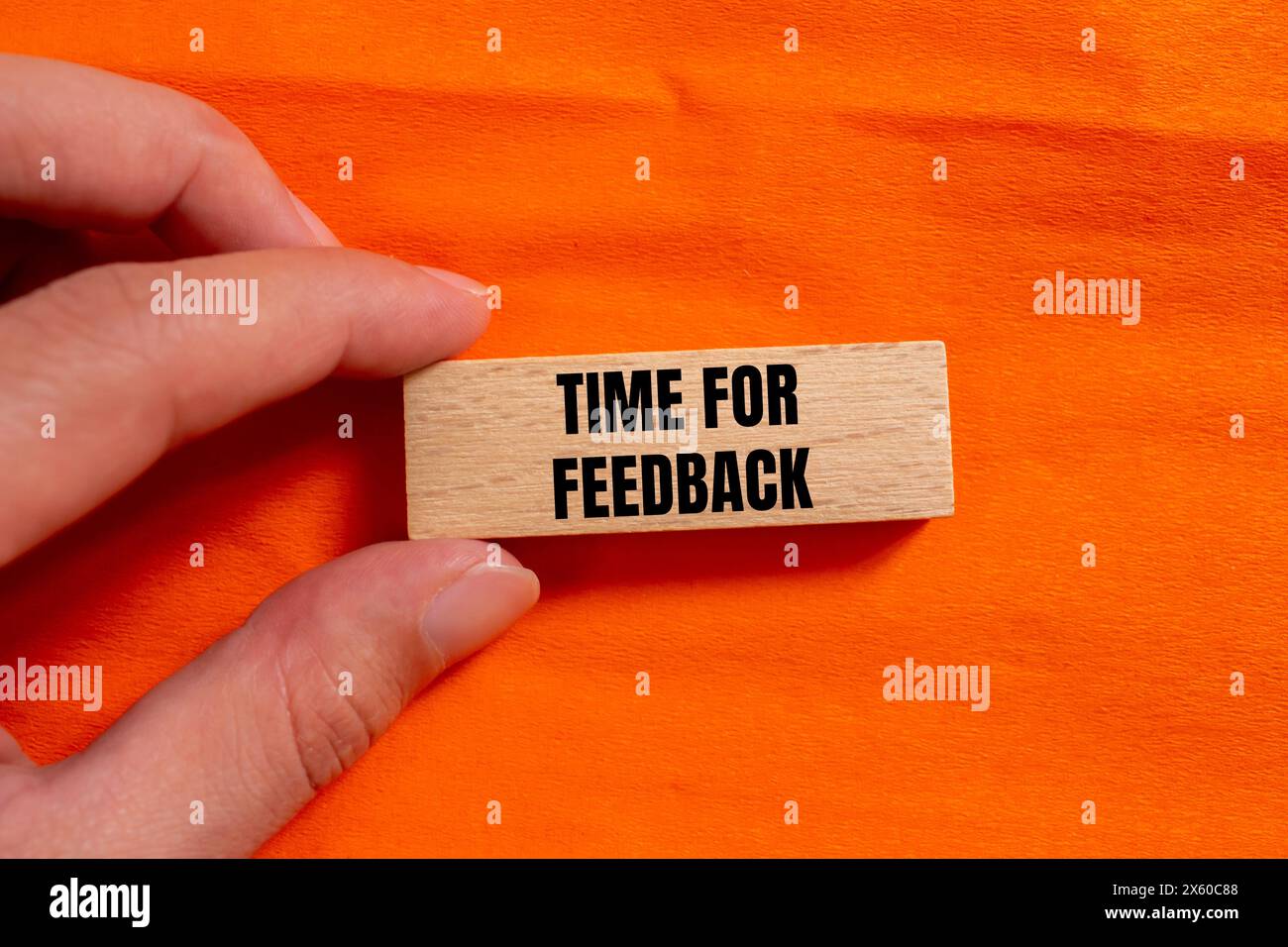 Time for feedback words written on wooden block with orange background ...