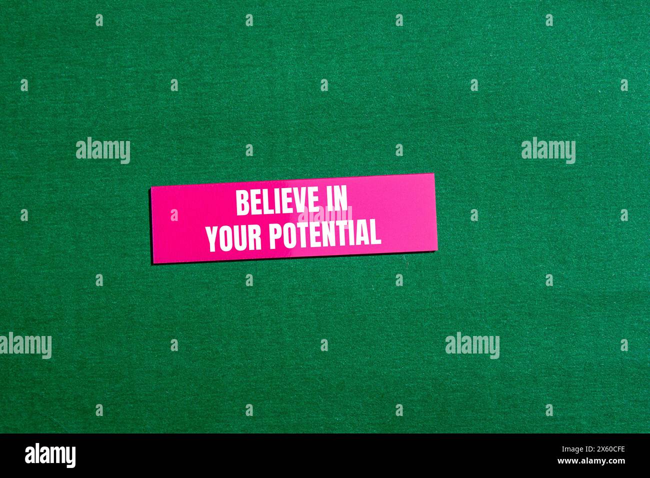 Believe in your potential words written on pink paper sticker with ...