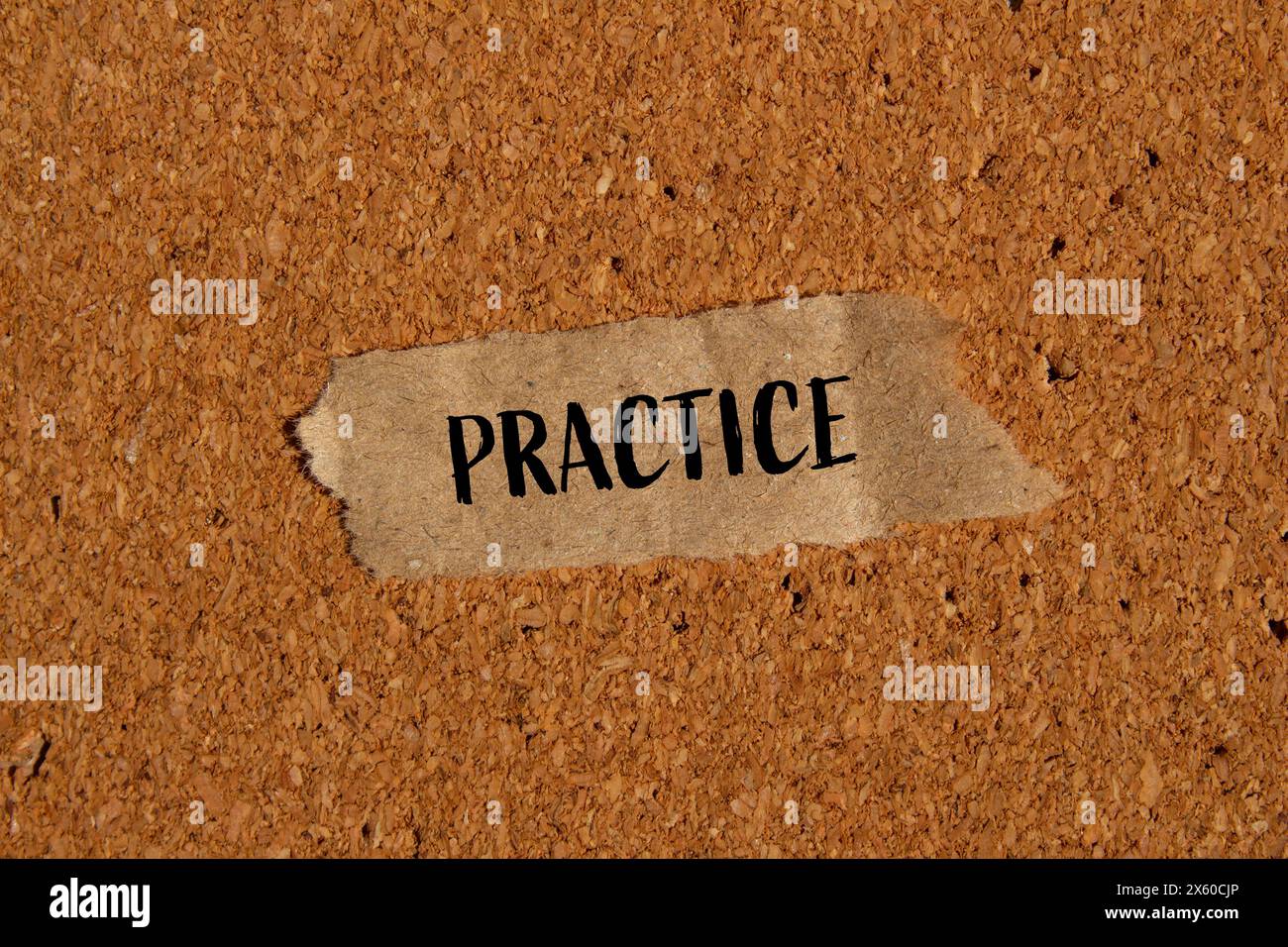 Practice word written on ripped paper piece with brown background ...