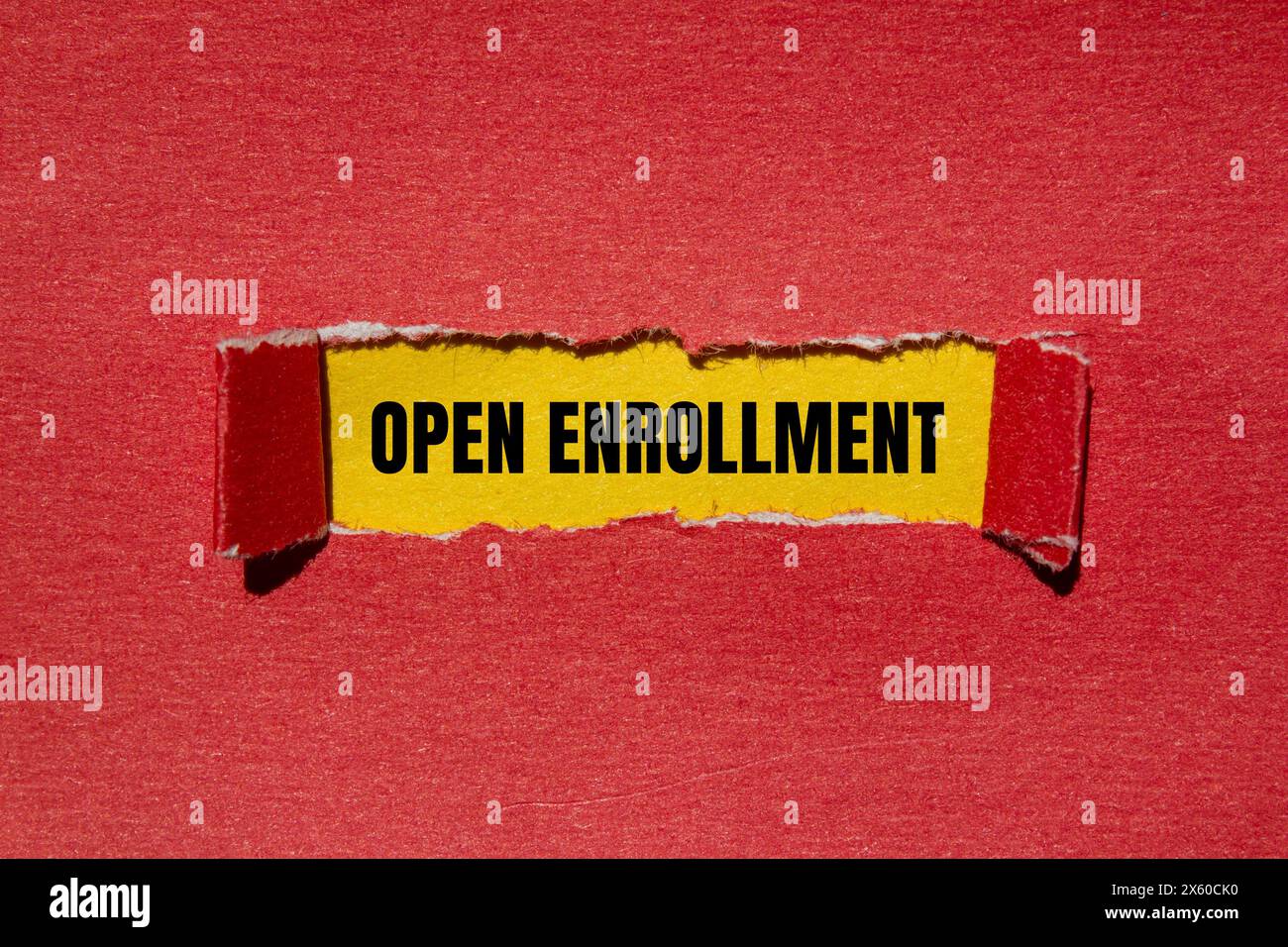 Open enrollment words written on ripped red paper with yellow ...