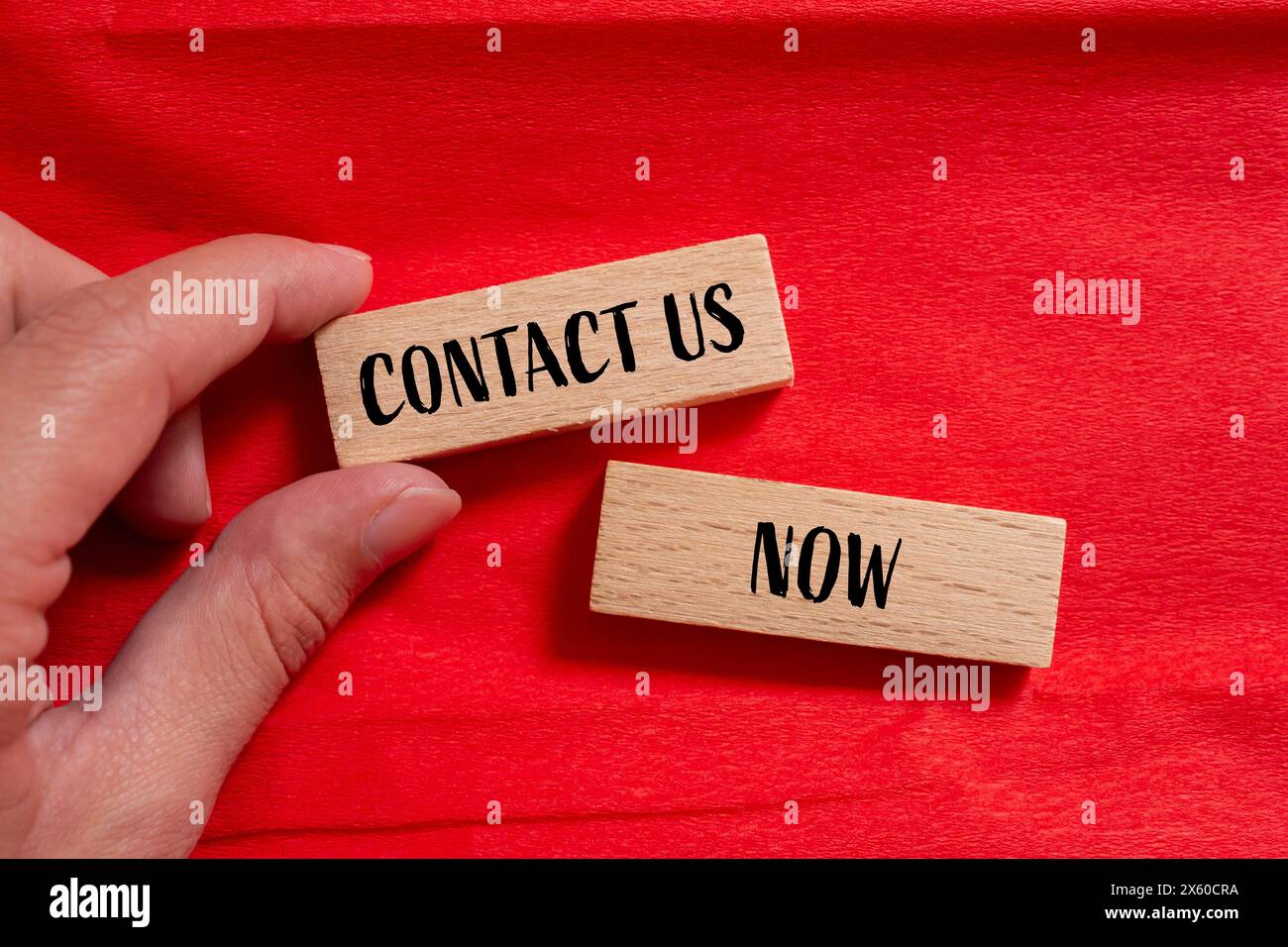 Contact us now words written on wooden blocks with red background ...