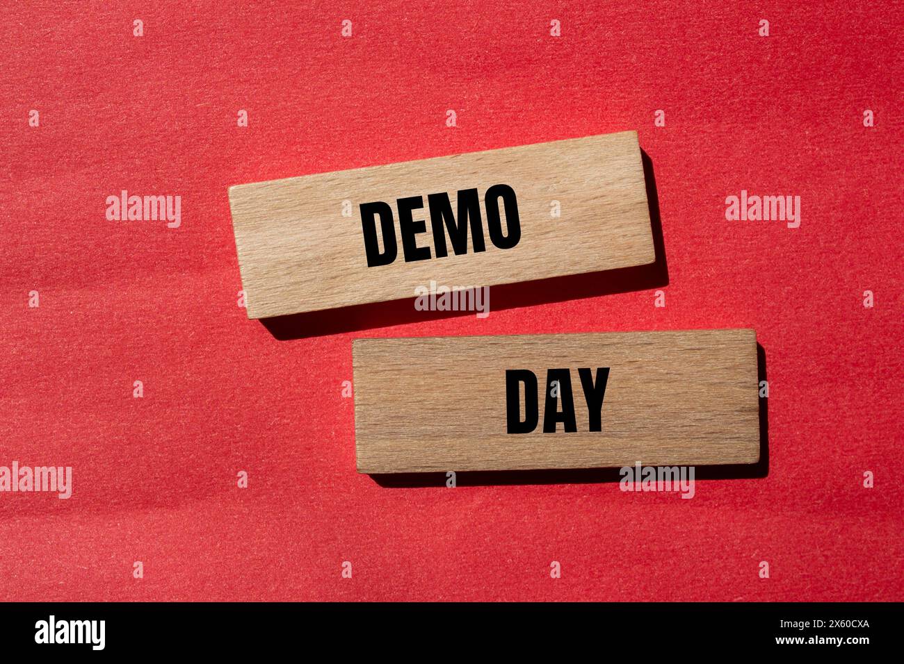 Demo day words written on wooden blocks with red background. Conceptual ...