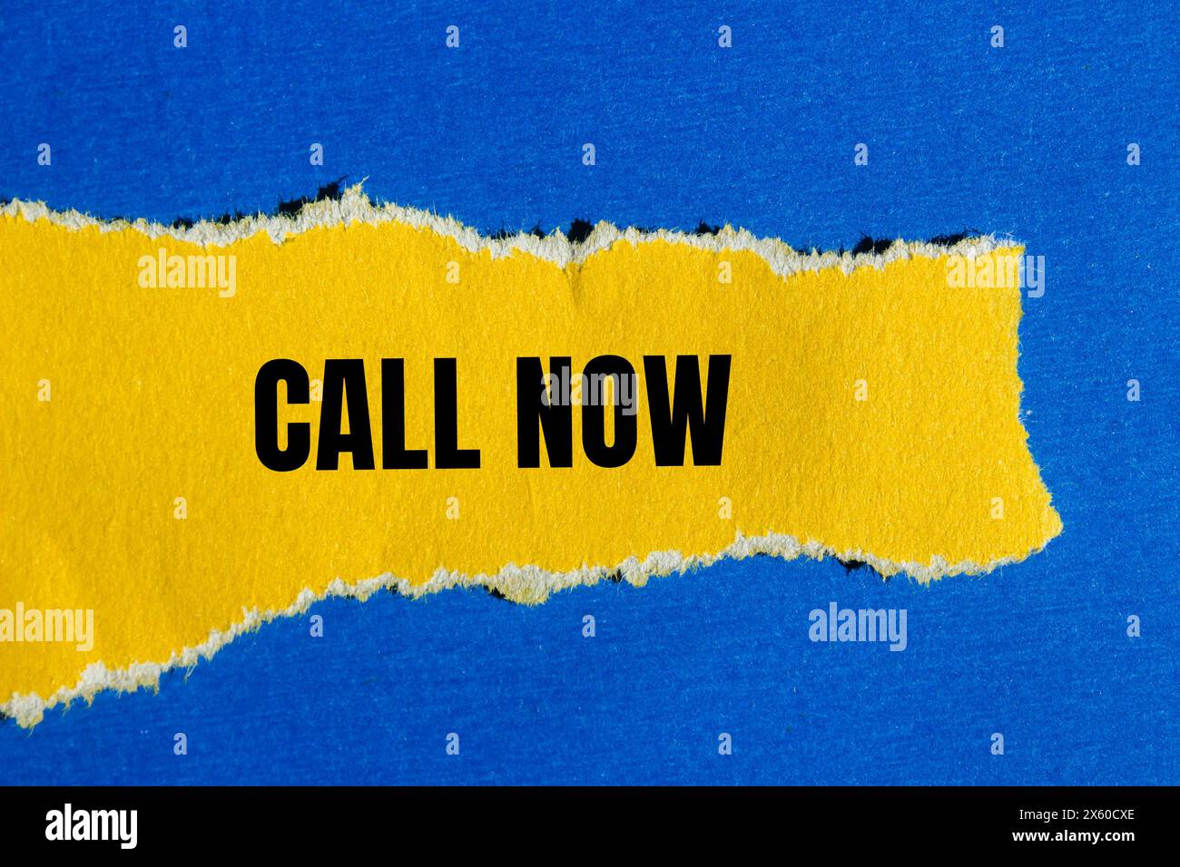 Call now words written on ripped yellow paper with blue background ...