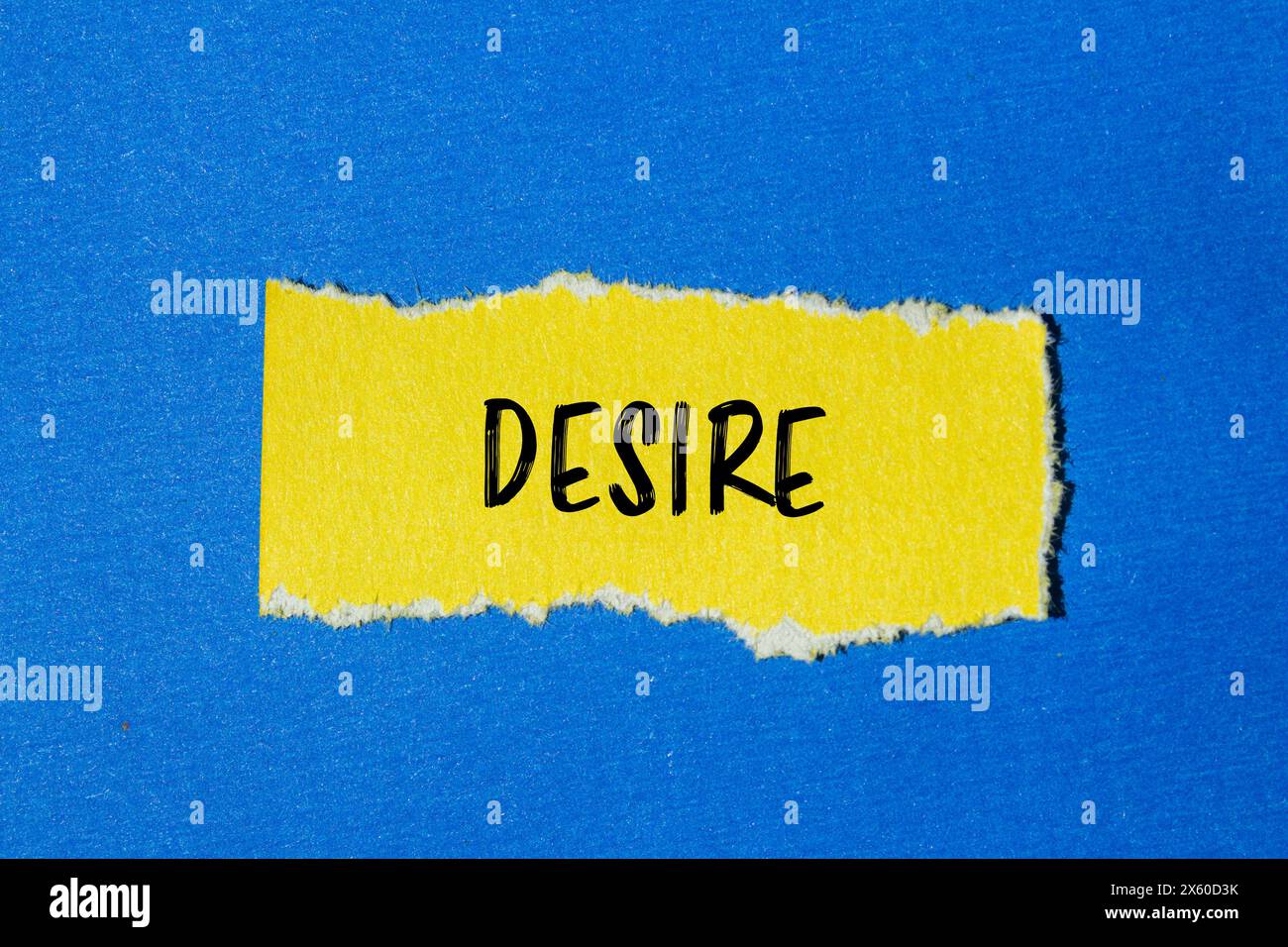 Desire word written on ripped yellow paper with blue background Stock ...