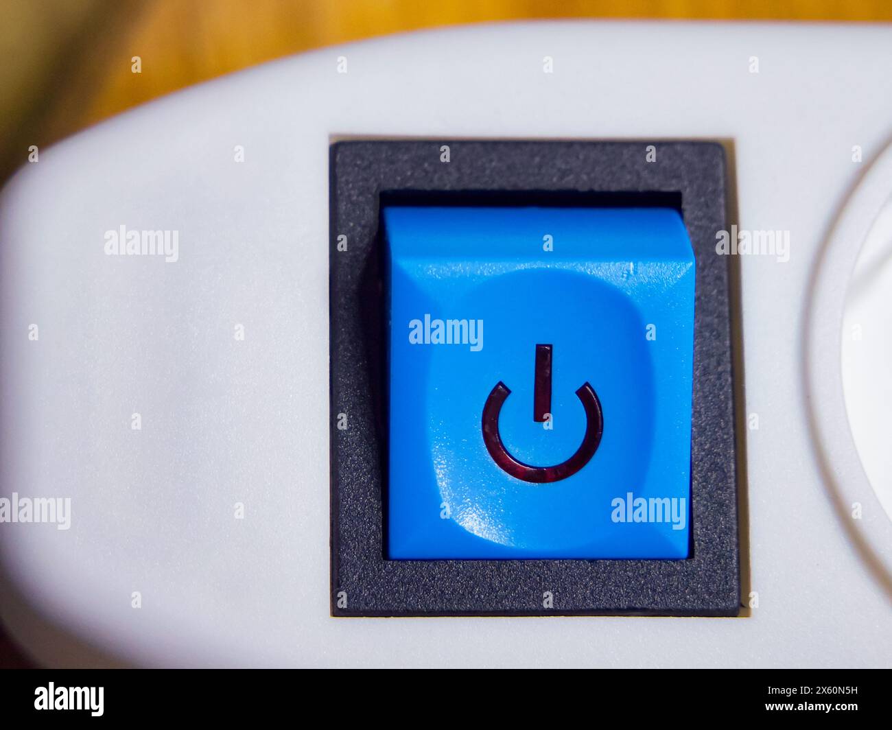 A blue power button with a power icon, set on a white device ...