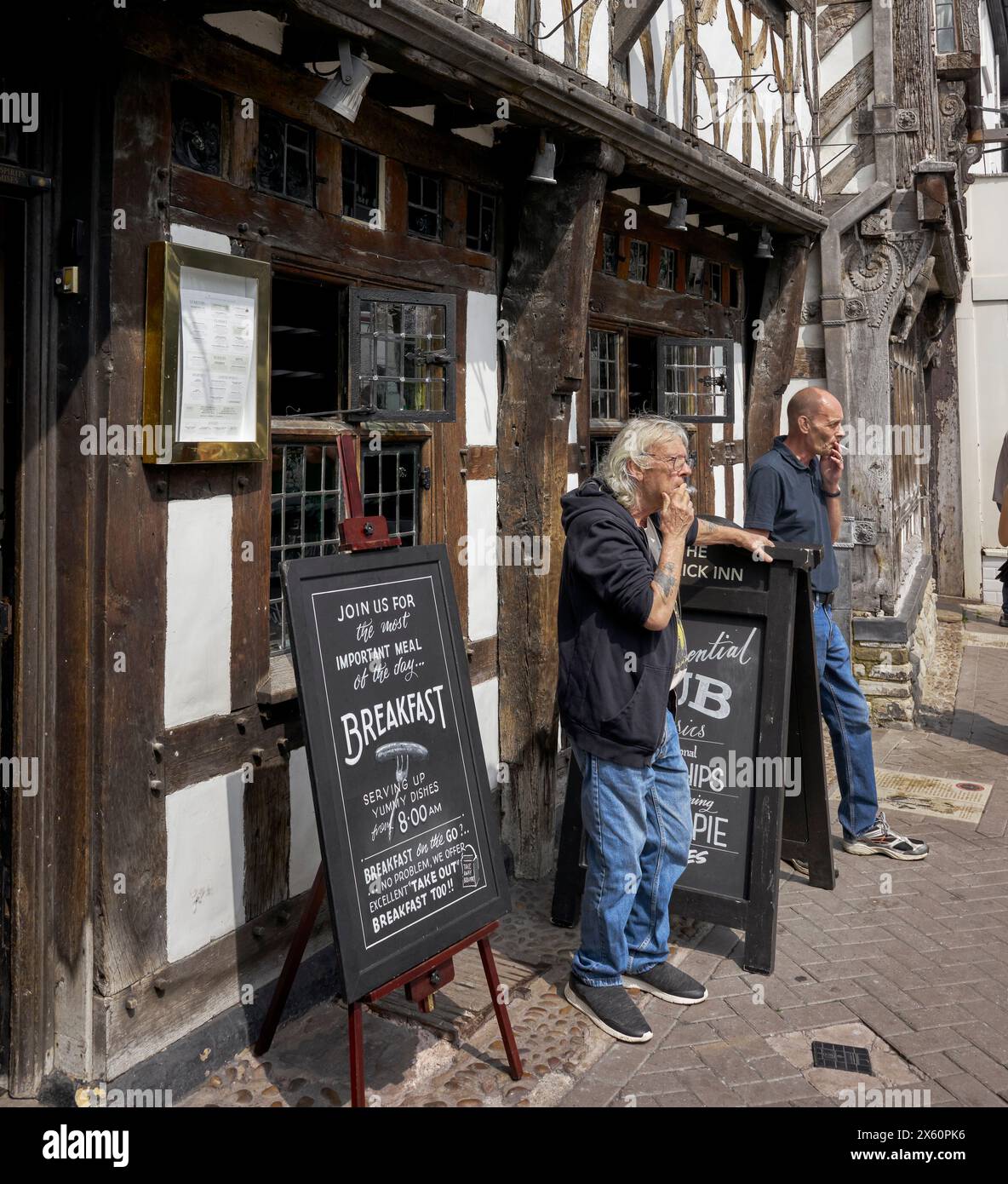 Men smoking cigarettes outside a public house with no smoking allowed ...