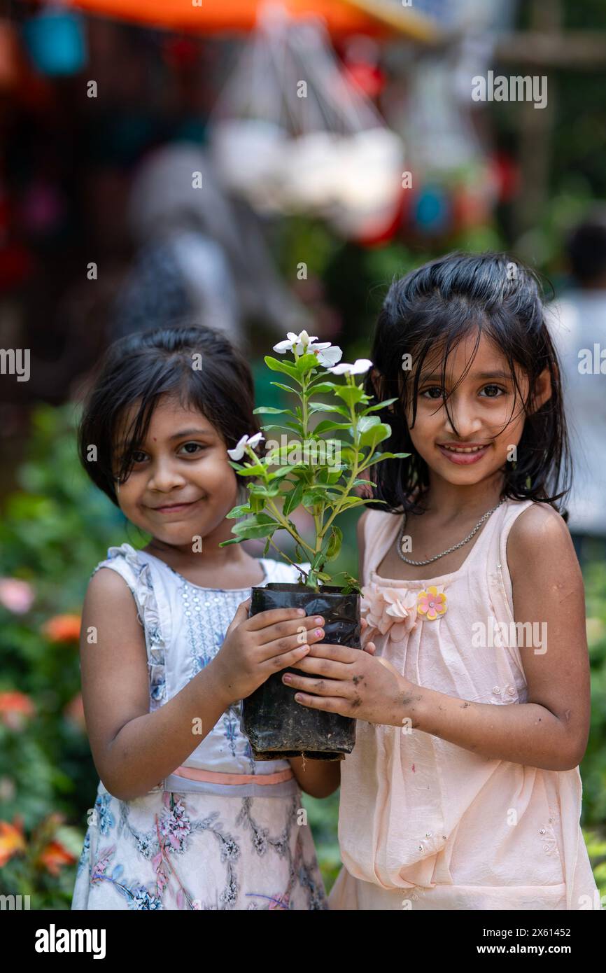 Two girls holding a plant Stock Photo - Alamy