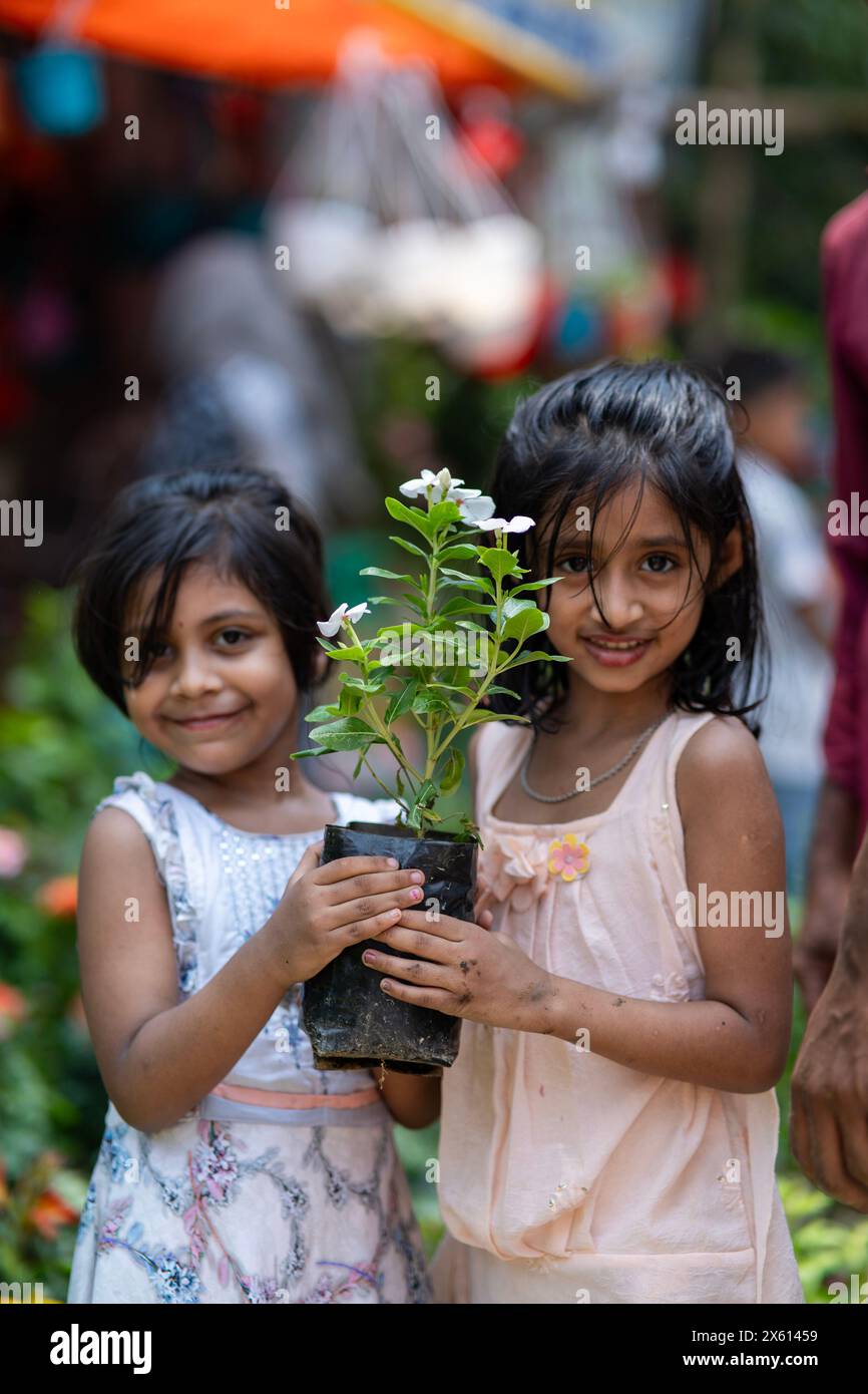 Two girls holding a plant Stock Photo - Alamy