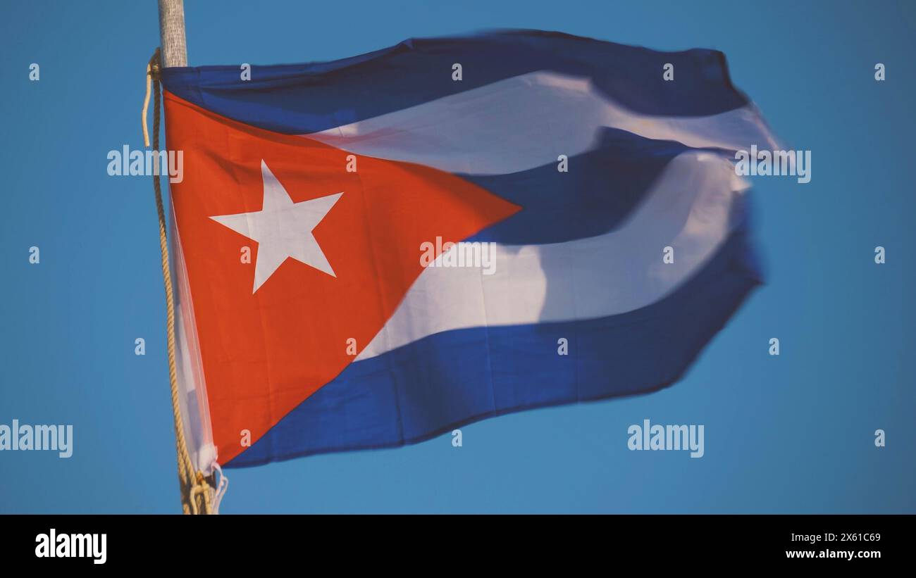 Cuba flag waving on wind against deep blue sky. Cuban flag - main ...