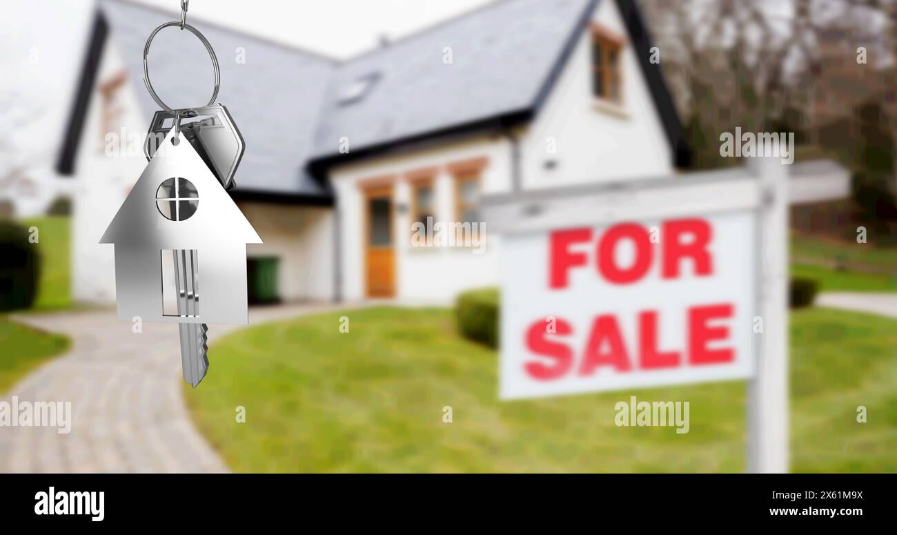 Image of silver house key fob and key, hanging in front of blurred ...