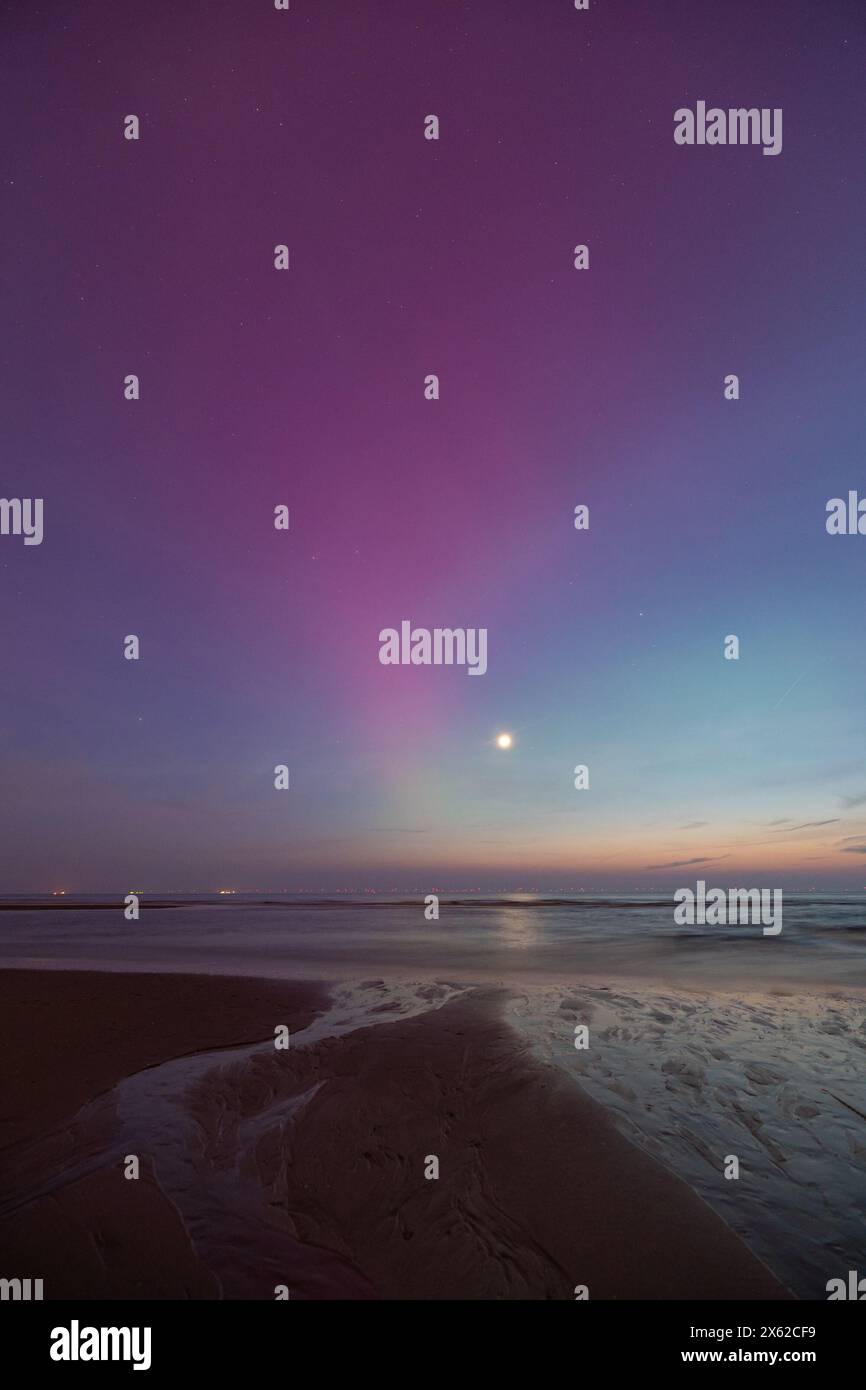 Moon with purple colored northern lights (Aurora borealis) over the ...