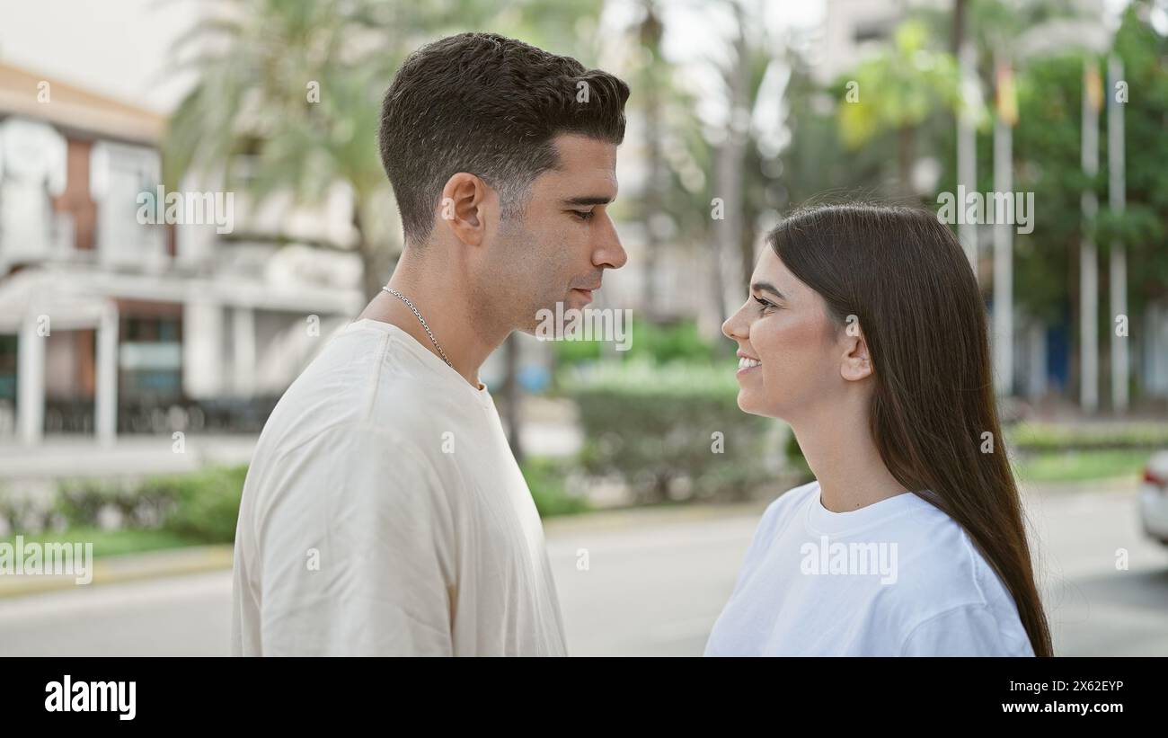A loving couple standing together on a city street, engaging in joyful ...