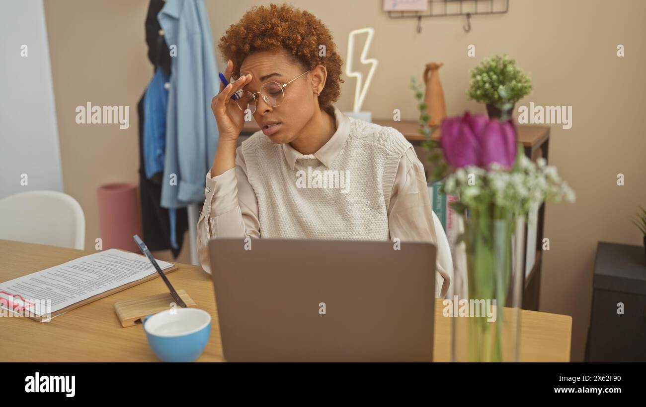 An african american woman appears stressed while working on a laptop at ...