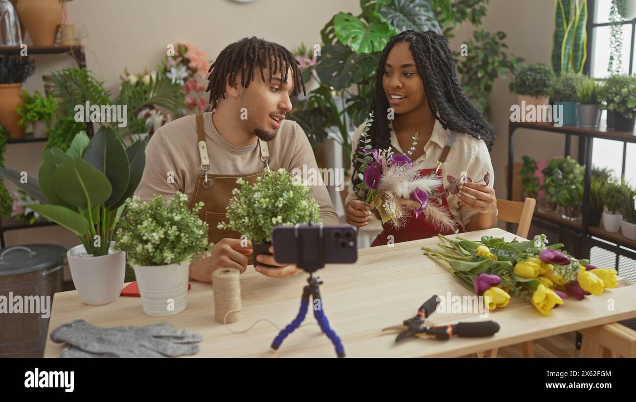 A man and a woman arrange flowers in a plant-filled flower shop ...