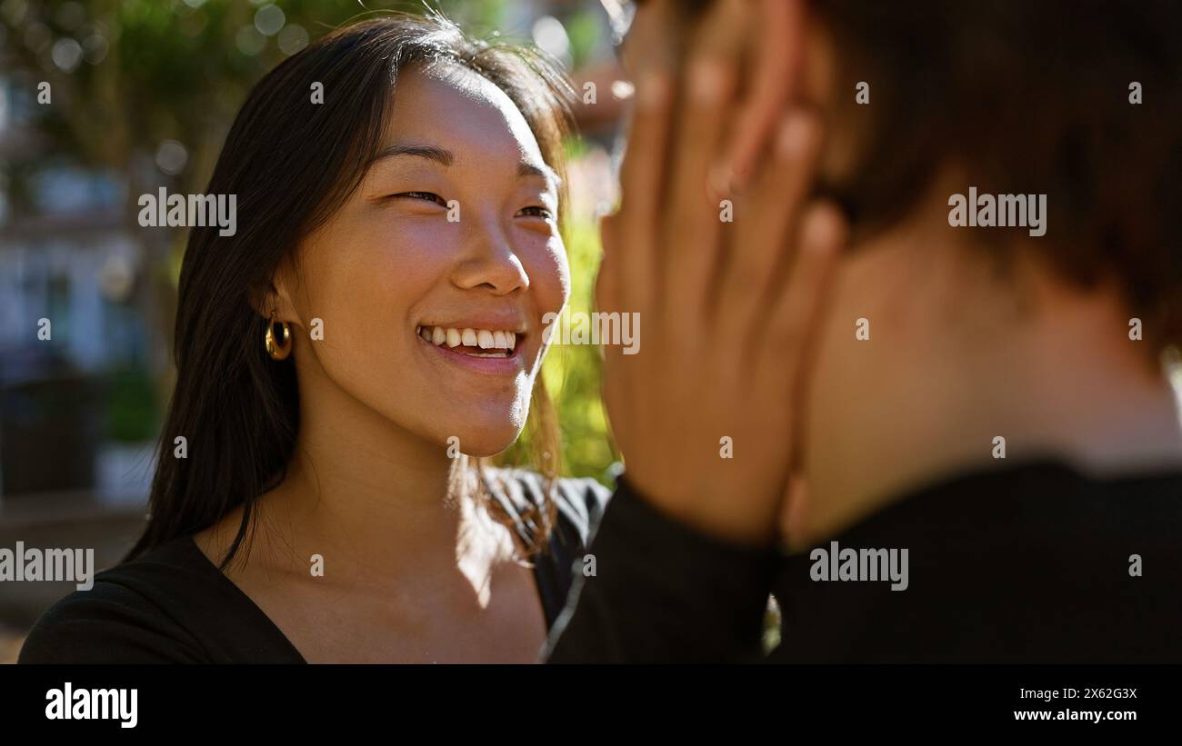 Close-up of a happy asian woman being affectionately touched by a man ...