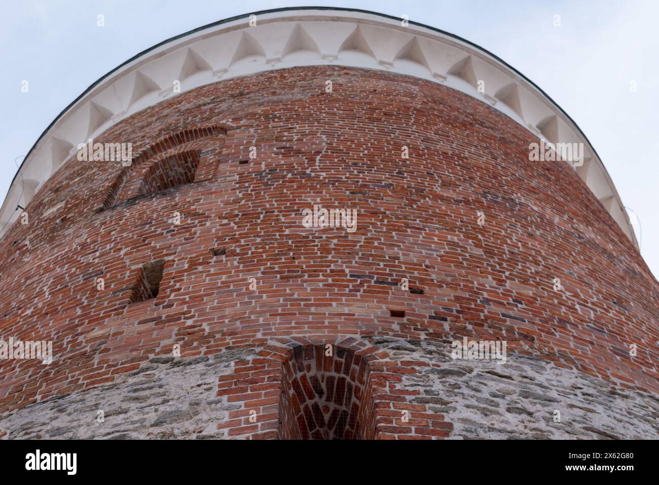 Wide red brick tower with windows in old town. View from bottom to top ...