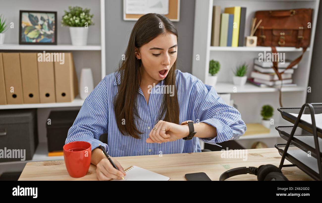 A surprised hispanic woman checks the time in a modern office ...