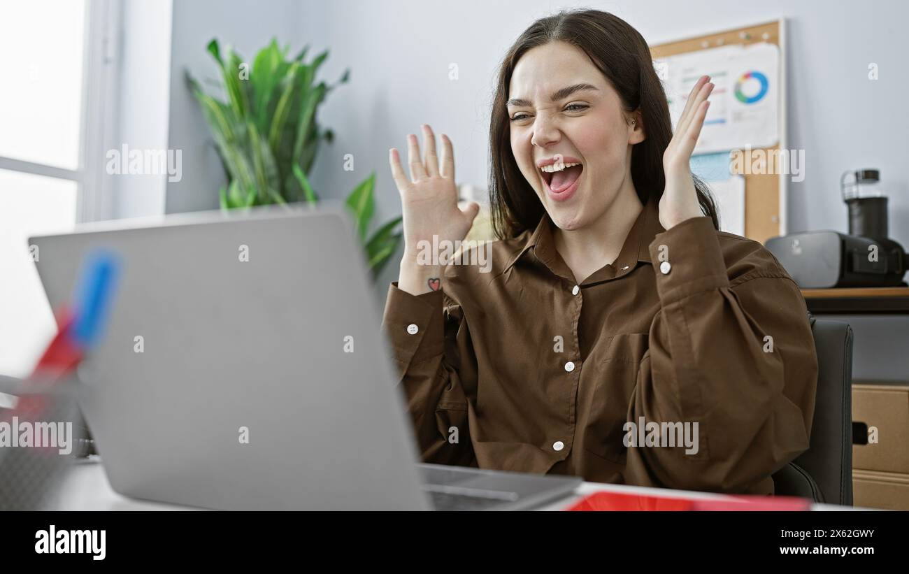 A delighted young caucasian woman is exuberantly expressing joy at her ...