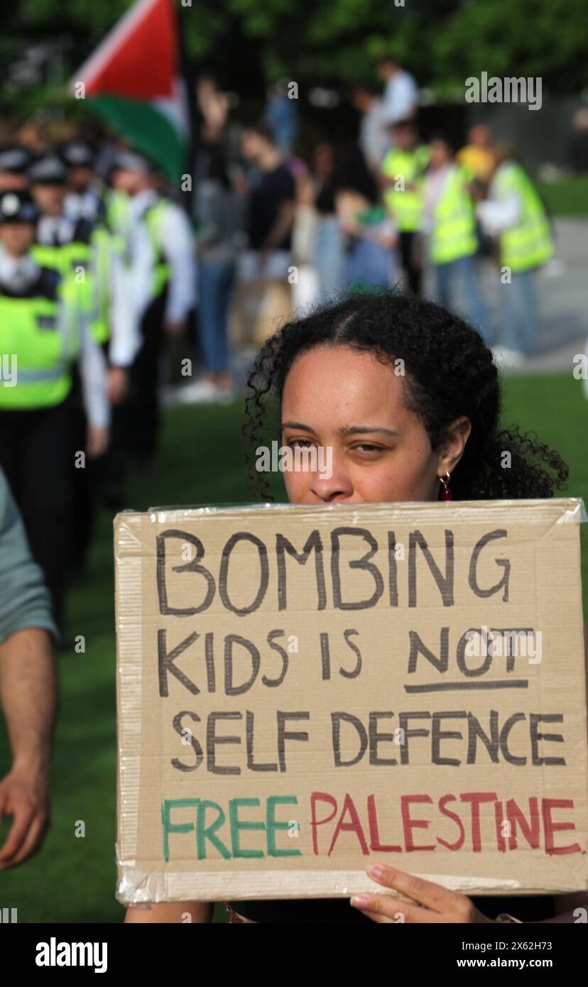 A protester carries a sign saying ‘Bombing Kids Is Not Self Defence ...