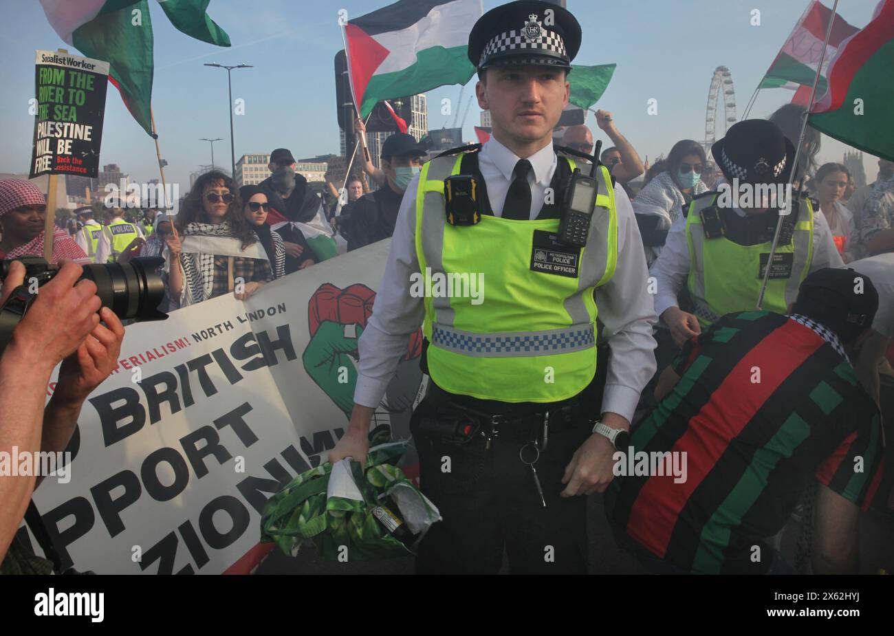 A police officer leaves the crowd who are blocking Waterloo Bridge ...