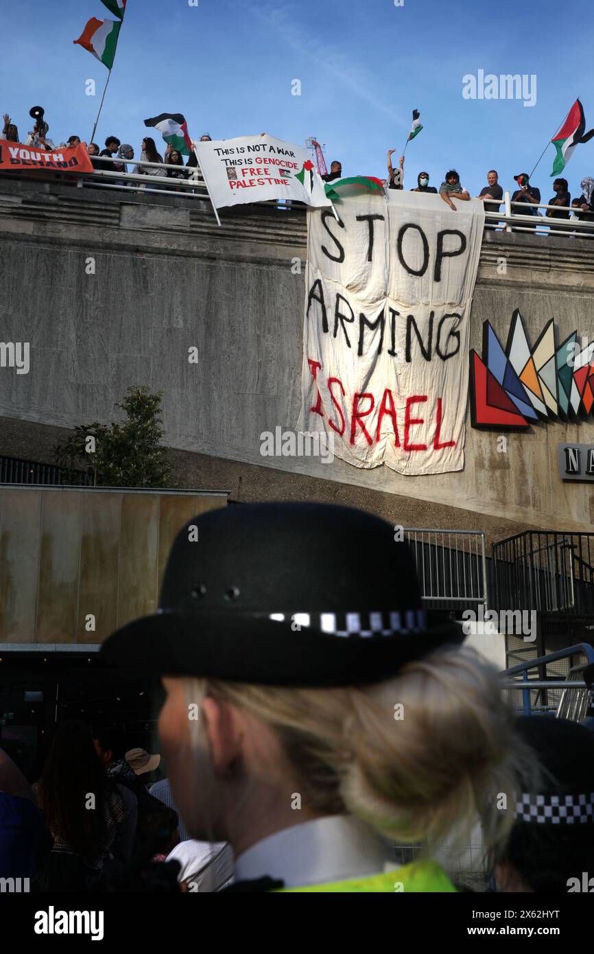 London, UK. 11th May, 2024. Protesters drop a banner from the side of ...