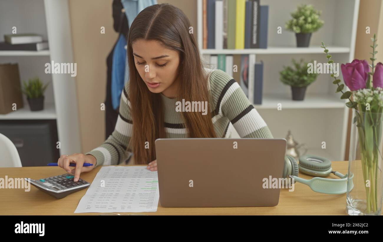 Focused hispanic woman calculating finances with calculator and laptop ...