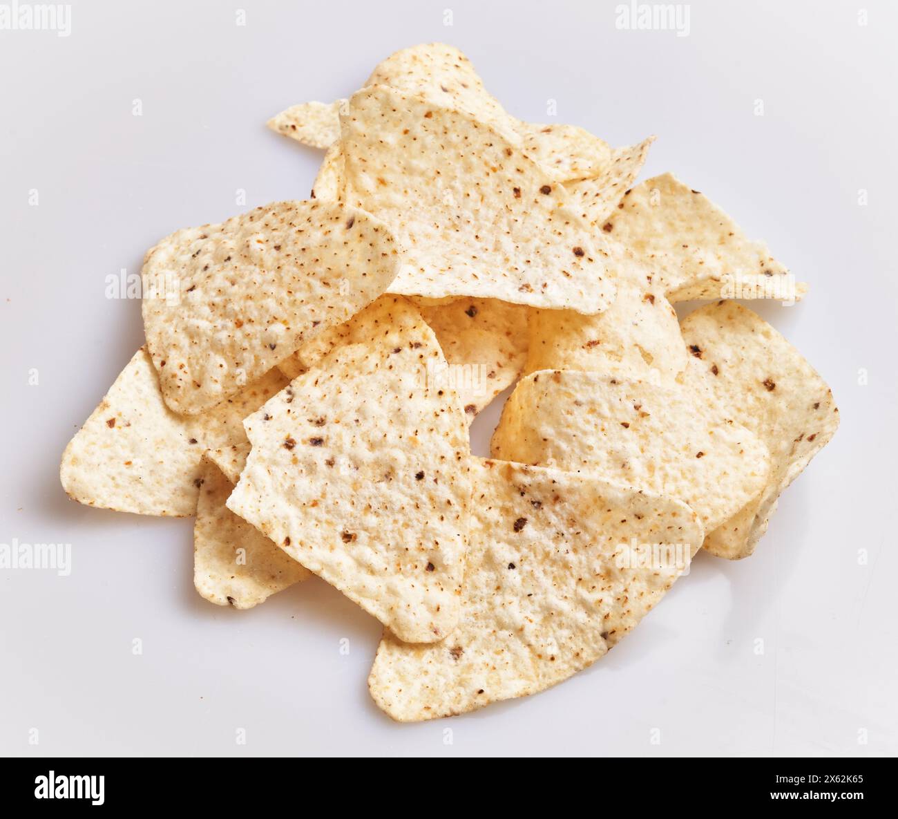 A pile of crispy tortilla chips scattered on a plain white background ...