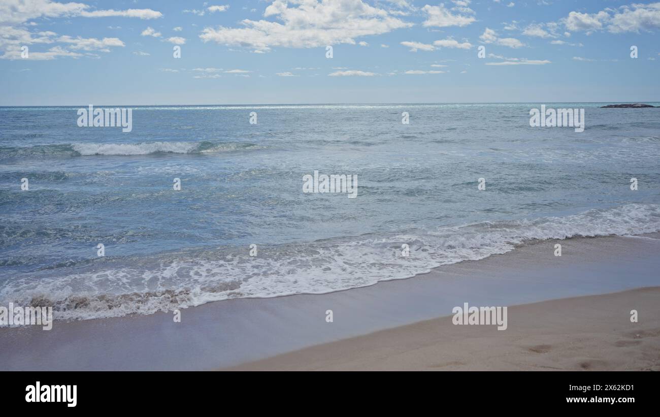 Serene beachscape with clear skies, gentle waves, and an inviting sandy ...