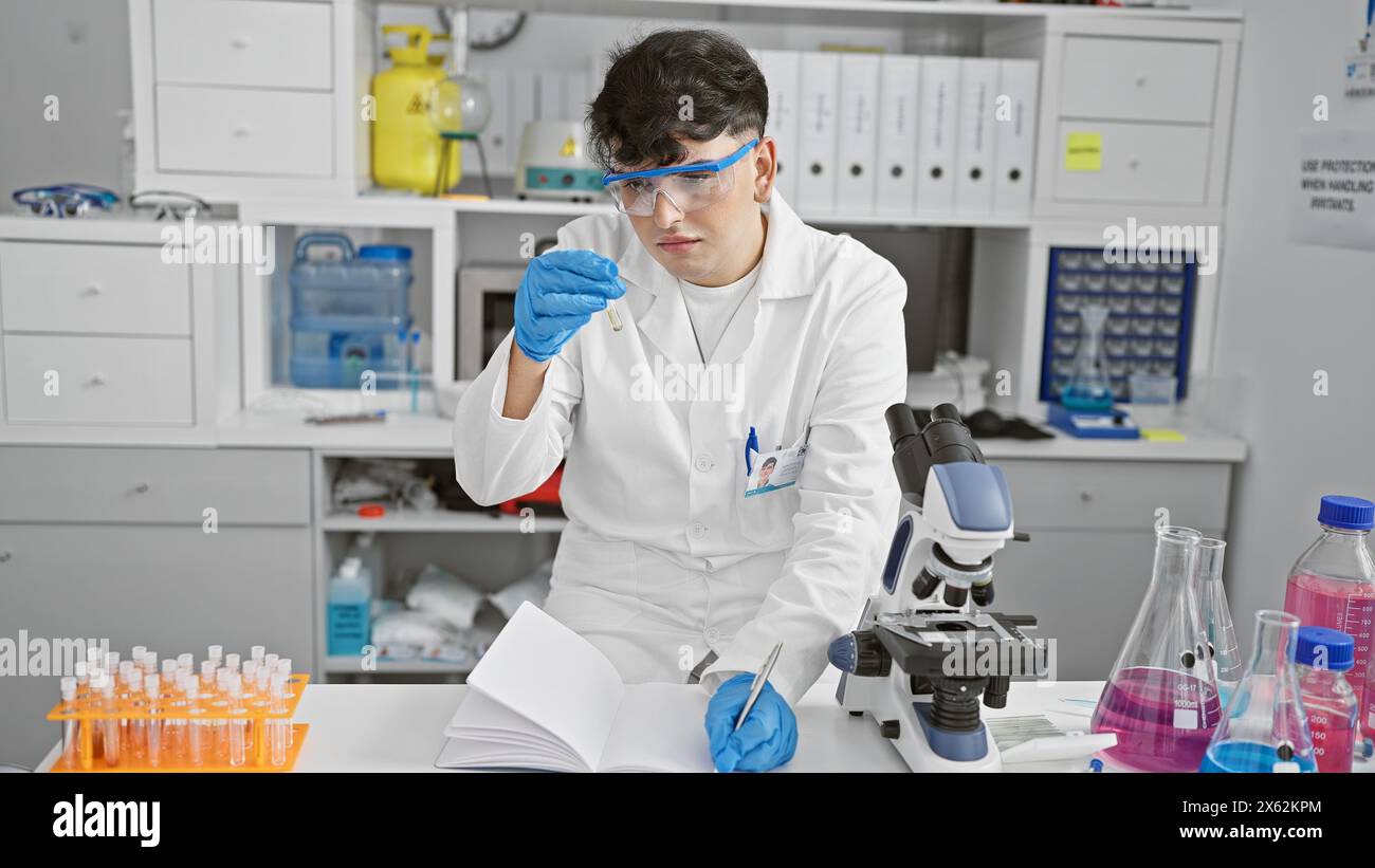 A focused male scientist analyzes a test tube in a well-equipped ...
