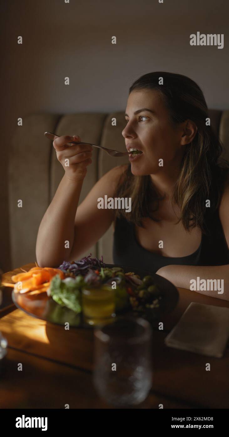 A young hispanic woman enjoys a healthy meal in a modern restaurant ...