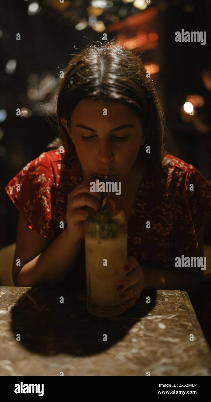 Cheerful, beautiful hispanic woman enjoying a tropical cocktail drink ...