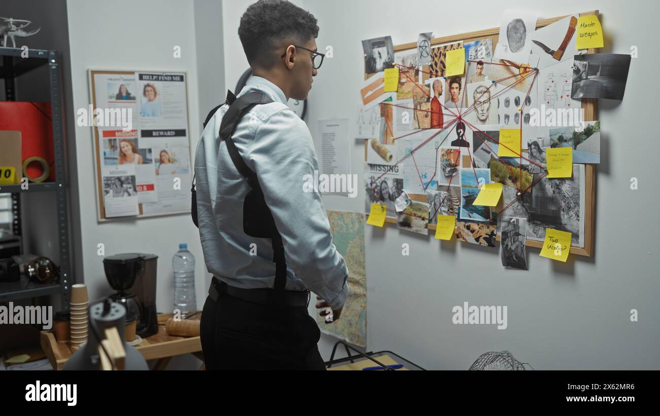 Man analyzes evidence on investigation board in police department room, implying detective work ...