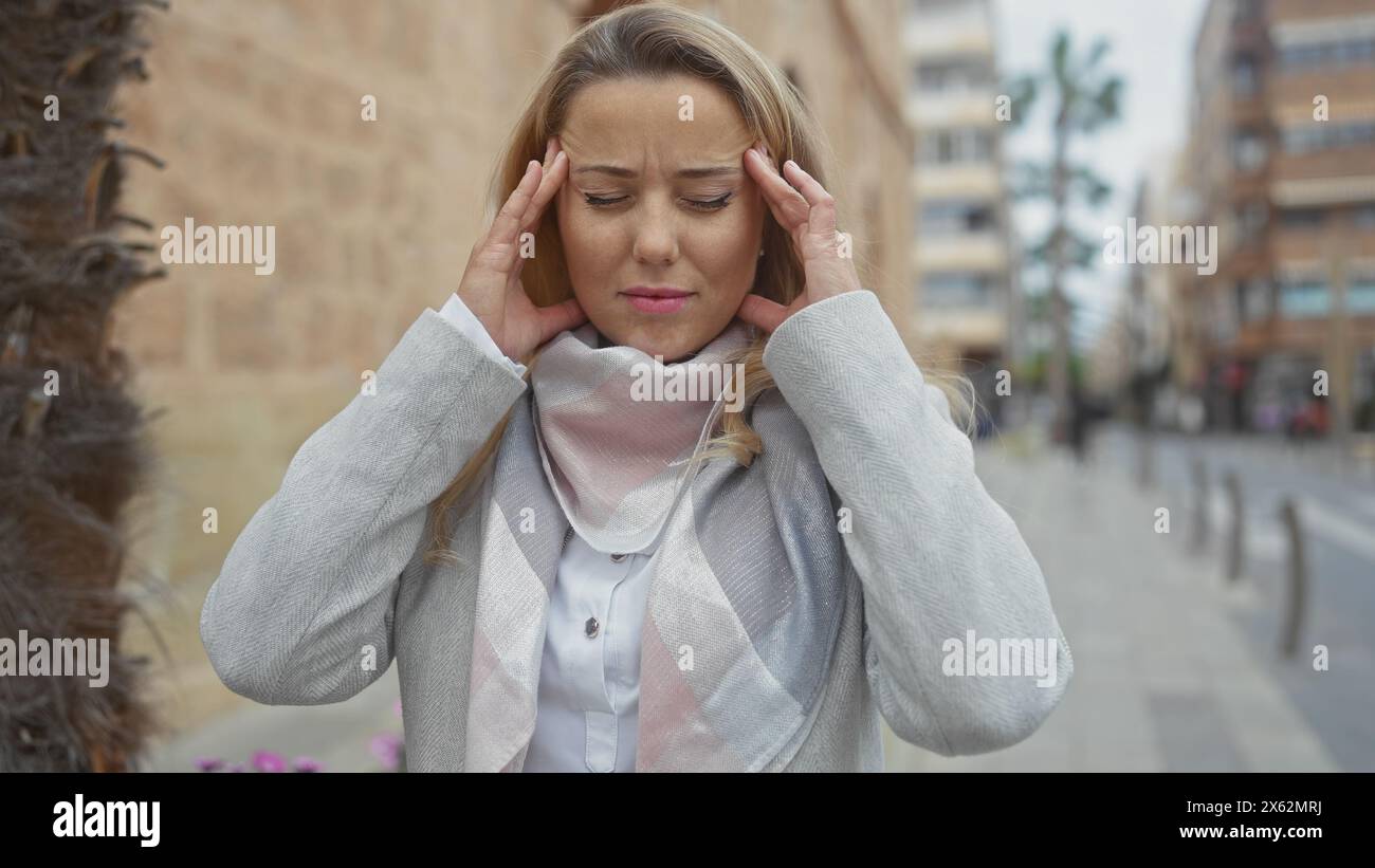 Portrait of a stressed young caucasian woman in an urban setting, with ...
