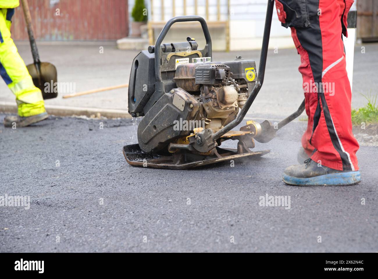 Construction Worker With Vibratory Plate During Asphalting - Vibratory ...