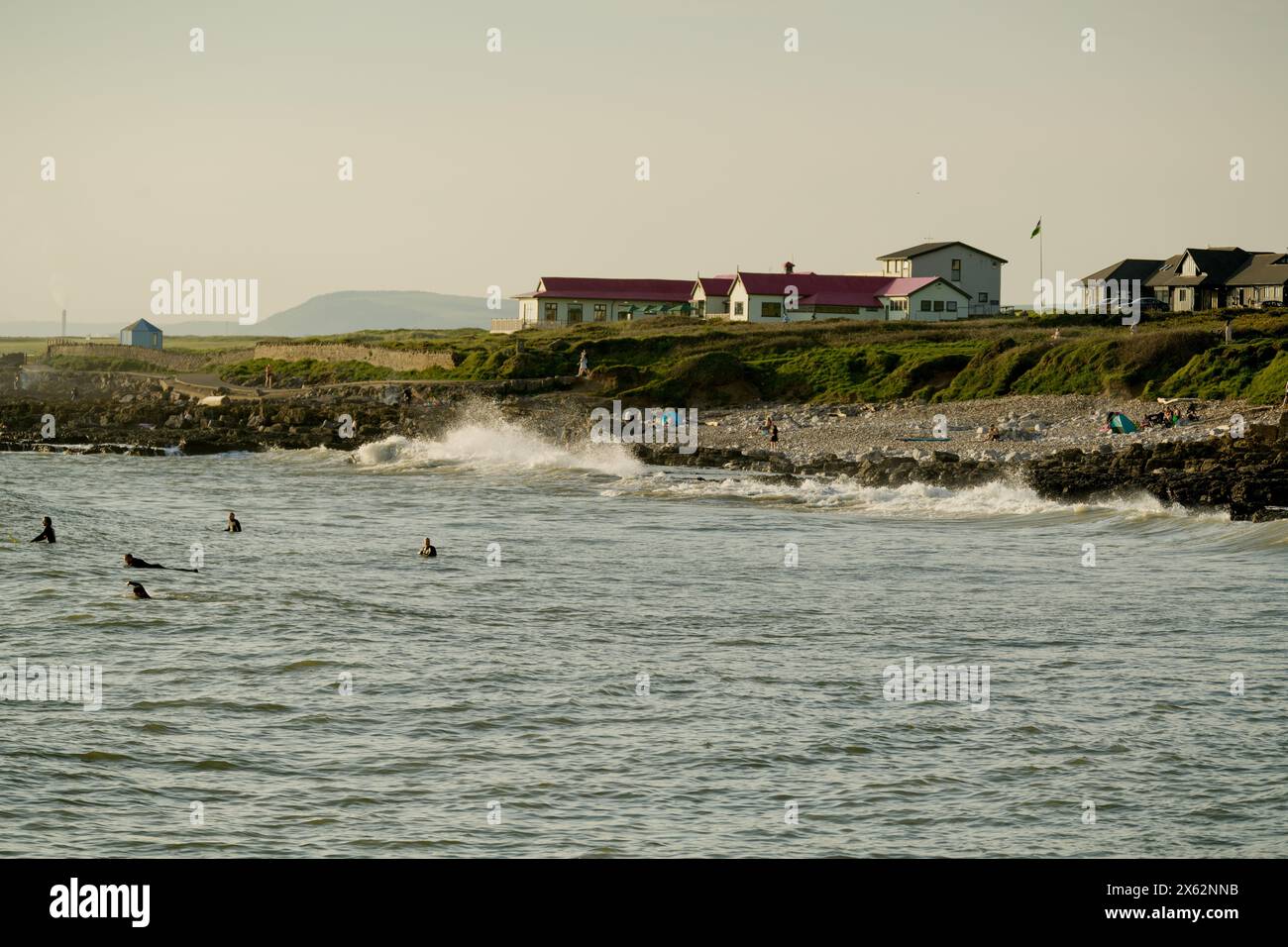 Bathers at sunset with The Royal Porthcawl Golf club in the background ...