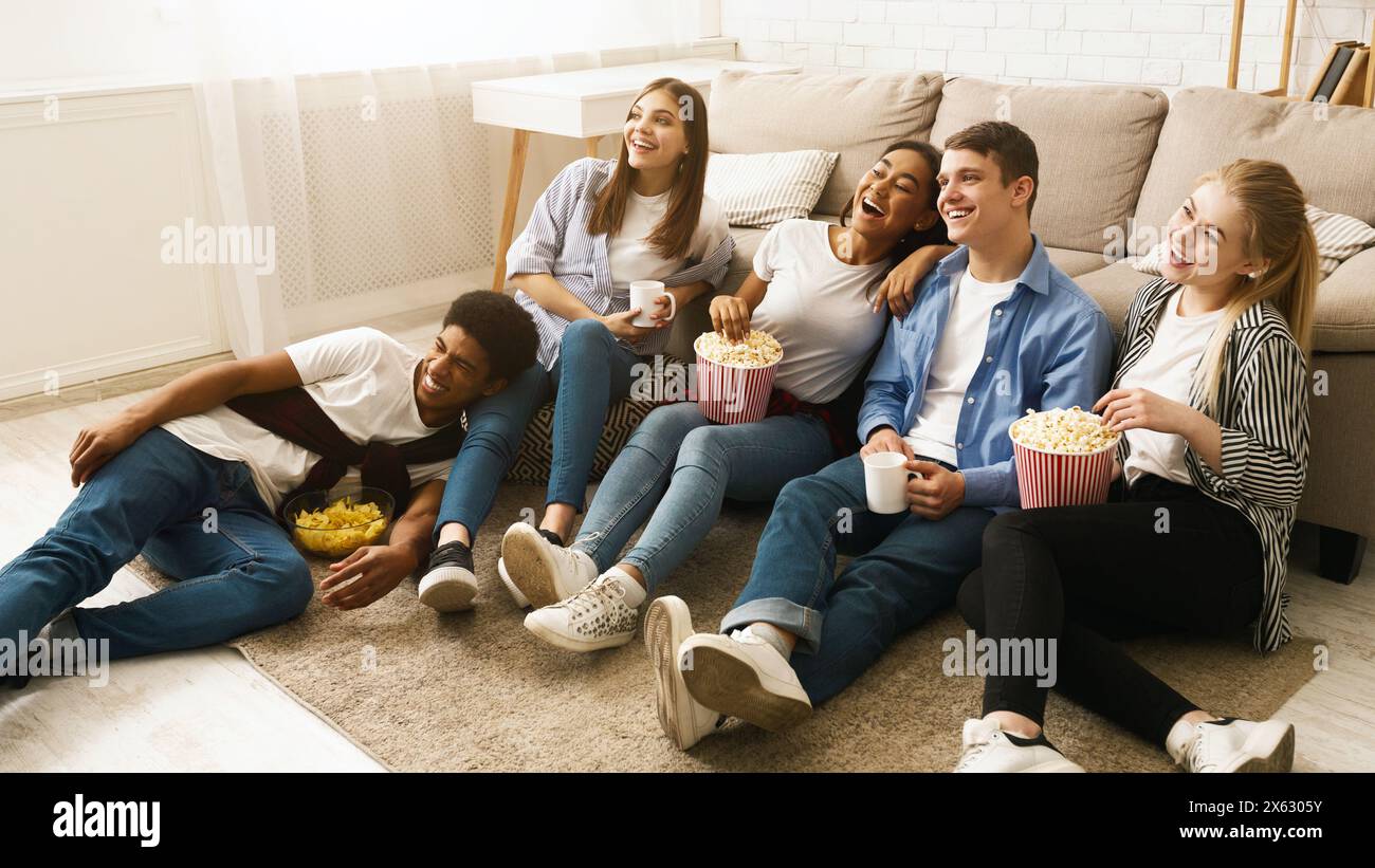Group of Teenagers Sitting on the Floor Eating Popcorn Stock Photo - Alamy