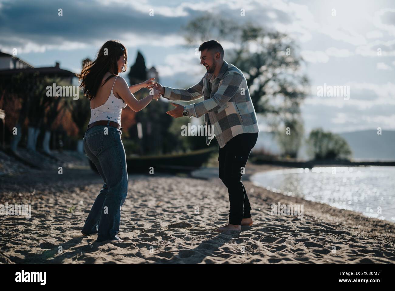 Joyful couple dancing on sandy beach during a romantic vacation Stock ...
