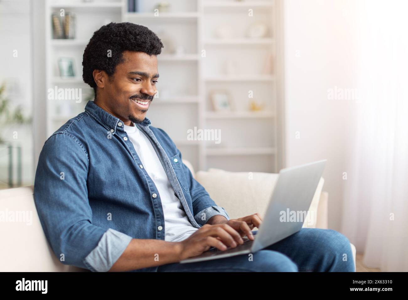 Man Sitting on Couch Using Laptop Computer Stock Photo - Alamy