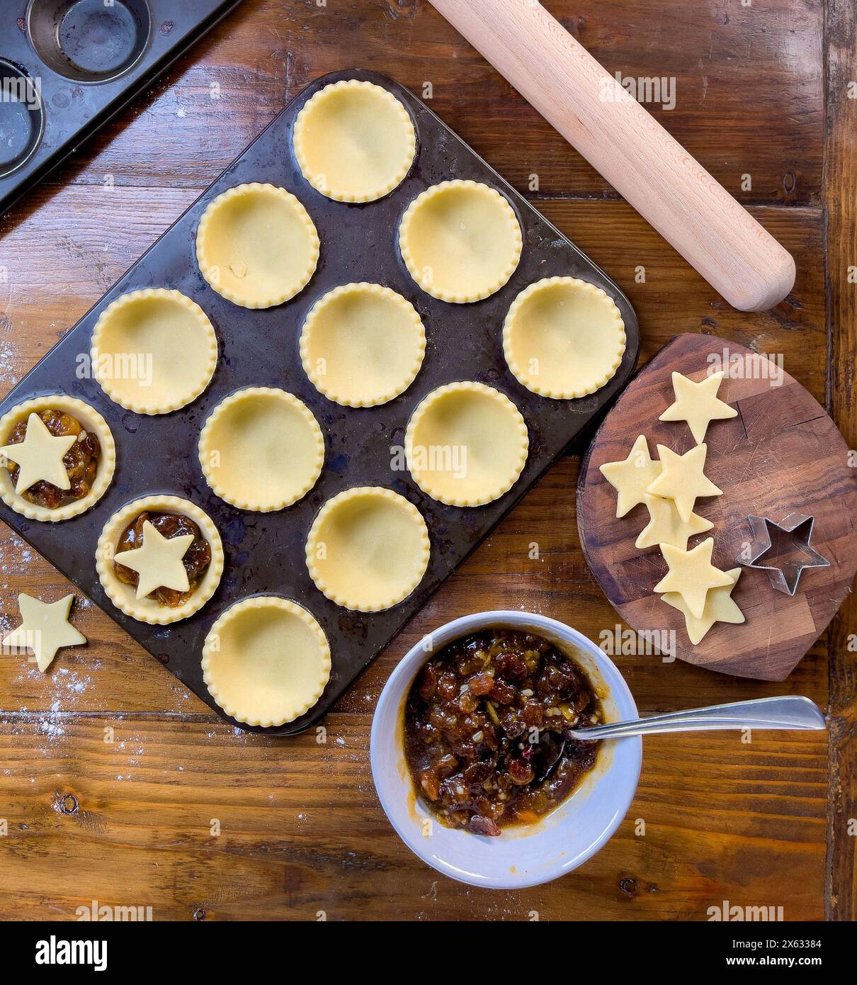Plan view of a metal bun tin lined with pastry, ready for mince pies ...