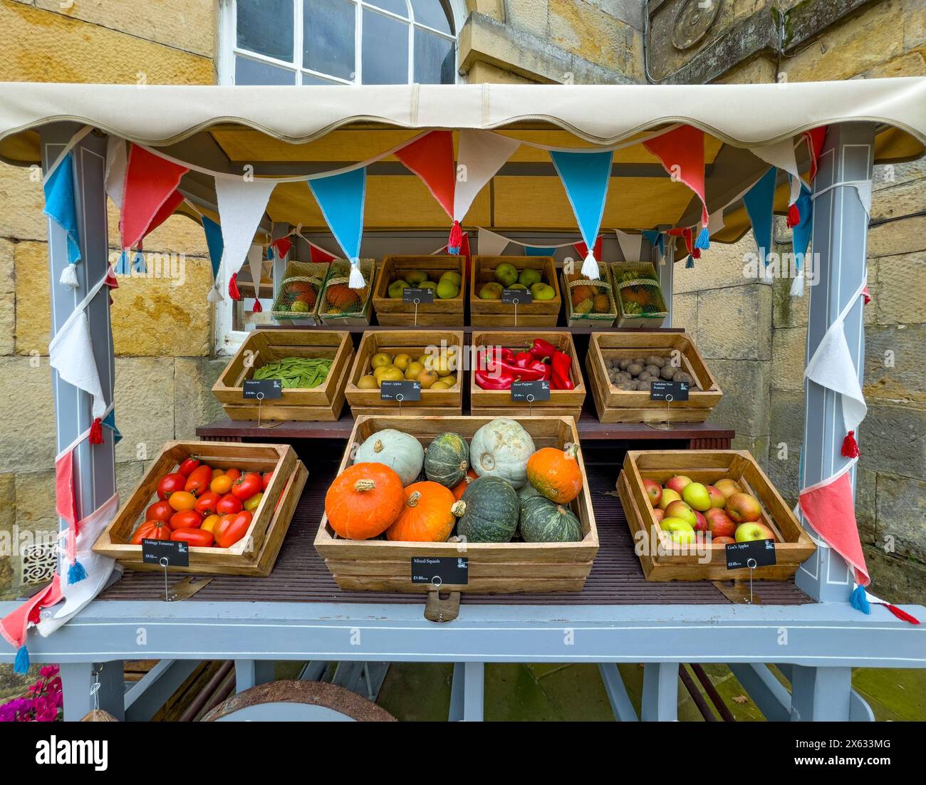 Blue-painted hand cart decorated with bunting displaying wooden boxes ...