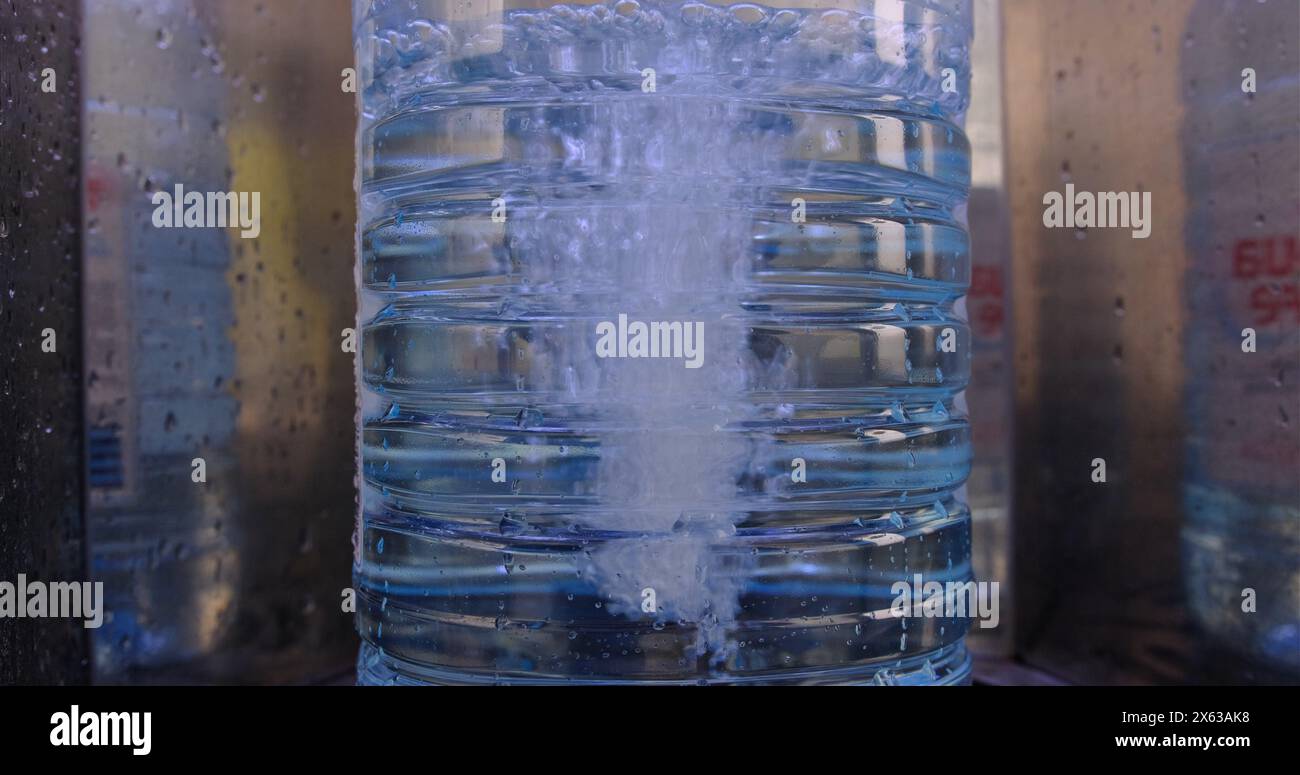 Close up of pouring water with 5 litre plastic water bottle at local ...
