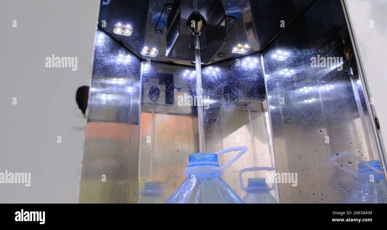 Close up of pouring water with 5 litre plastic water bottle at local ...