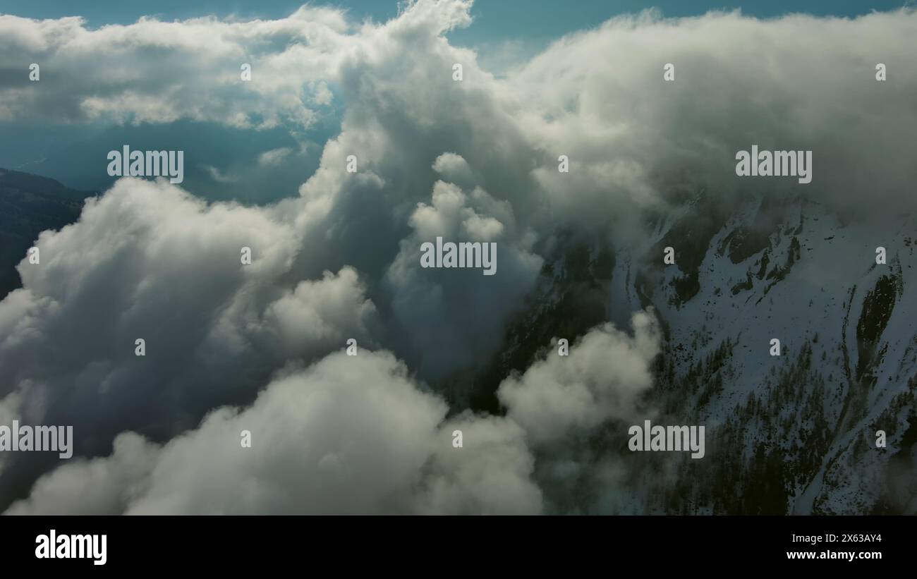 Flying through clouds between mountains Stock Photo - Alamy