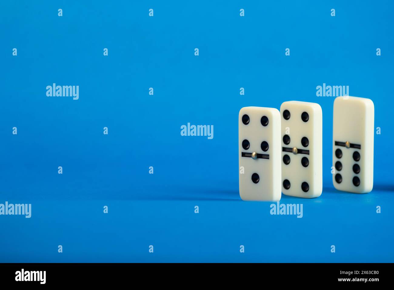 Dominoes standing on a blue background. White Bones Board Game Stock ...
