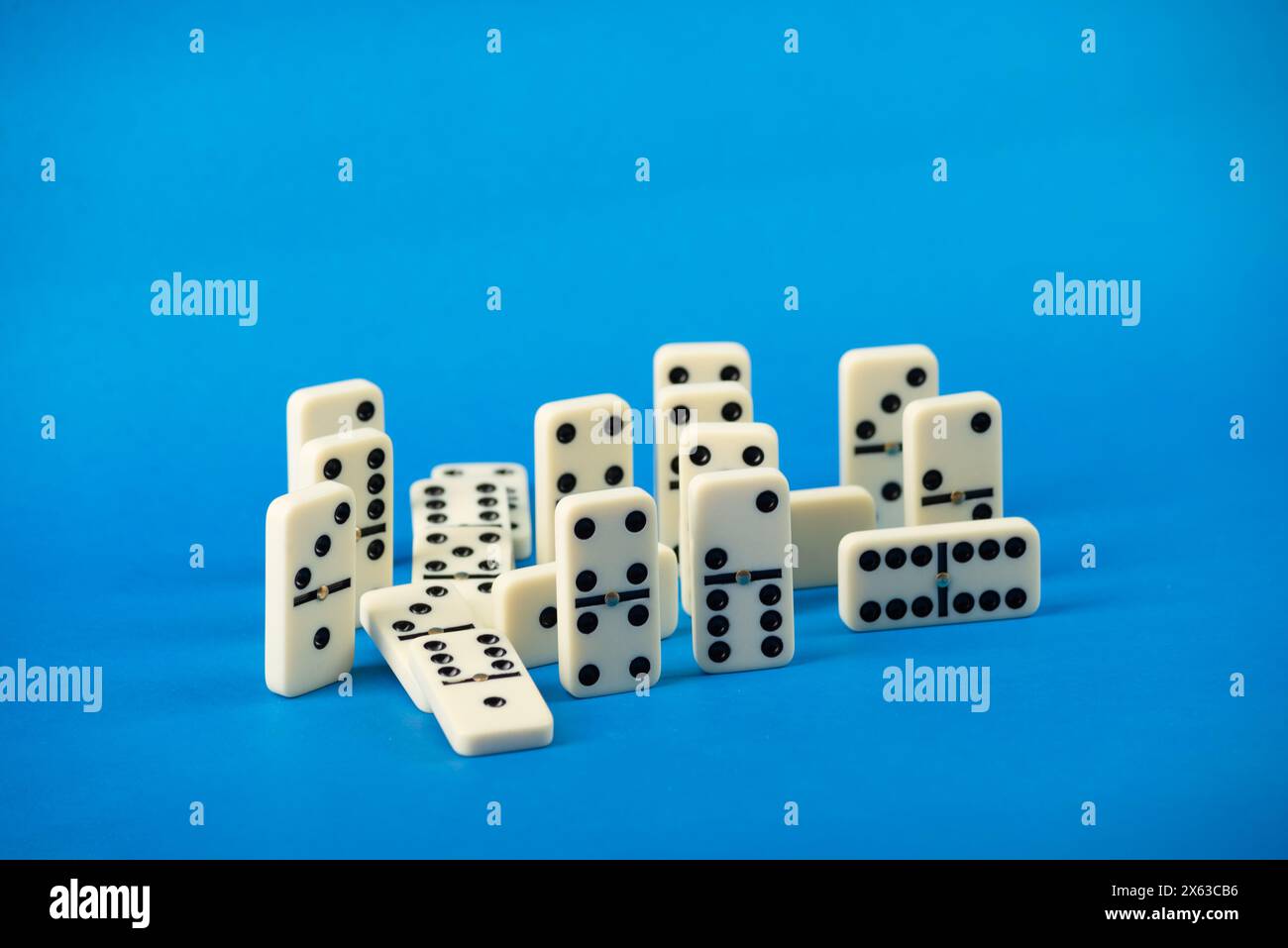 Dominoes standing on a blue background. White Bones Board Game Stock ...