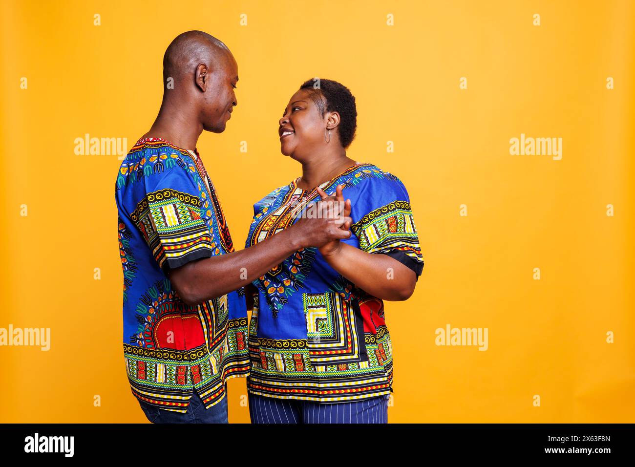 Happy african american spouse wearing ethnic clothes dancing slow dance ...