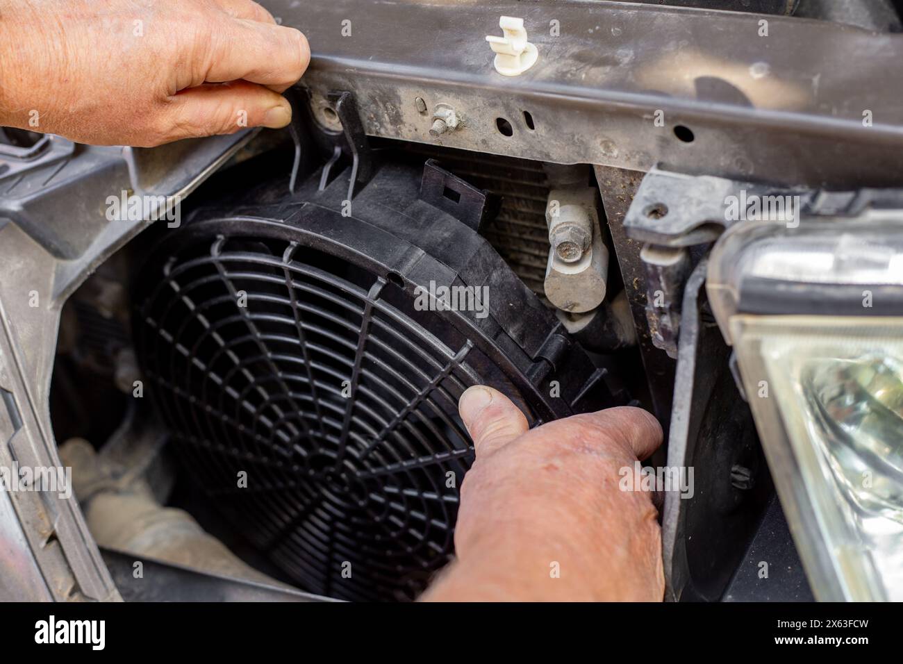 installing a car engine cooling fan under the radiator grille. Car ...